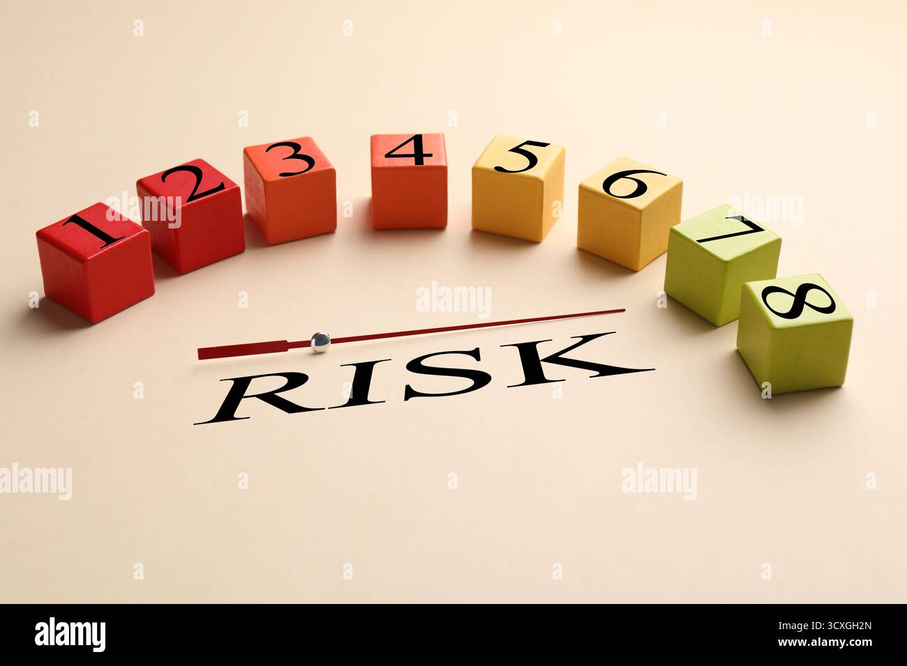 Arrow indicating level of risk on scale made of colorful cubes on beige ...