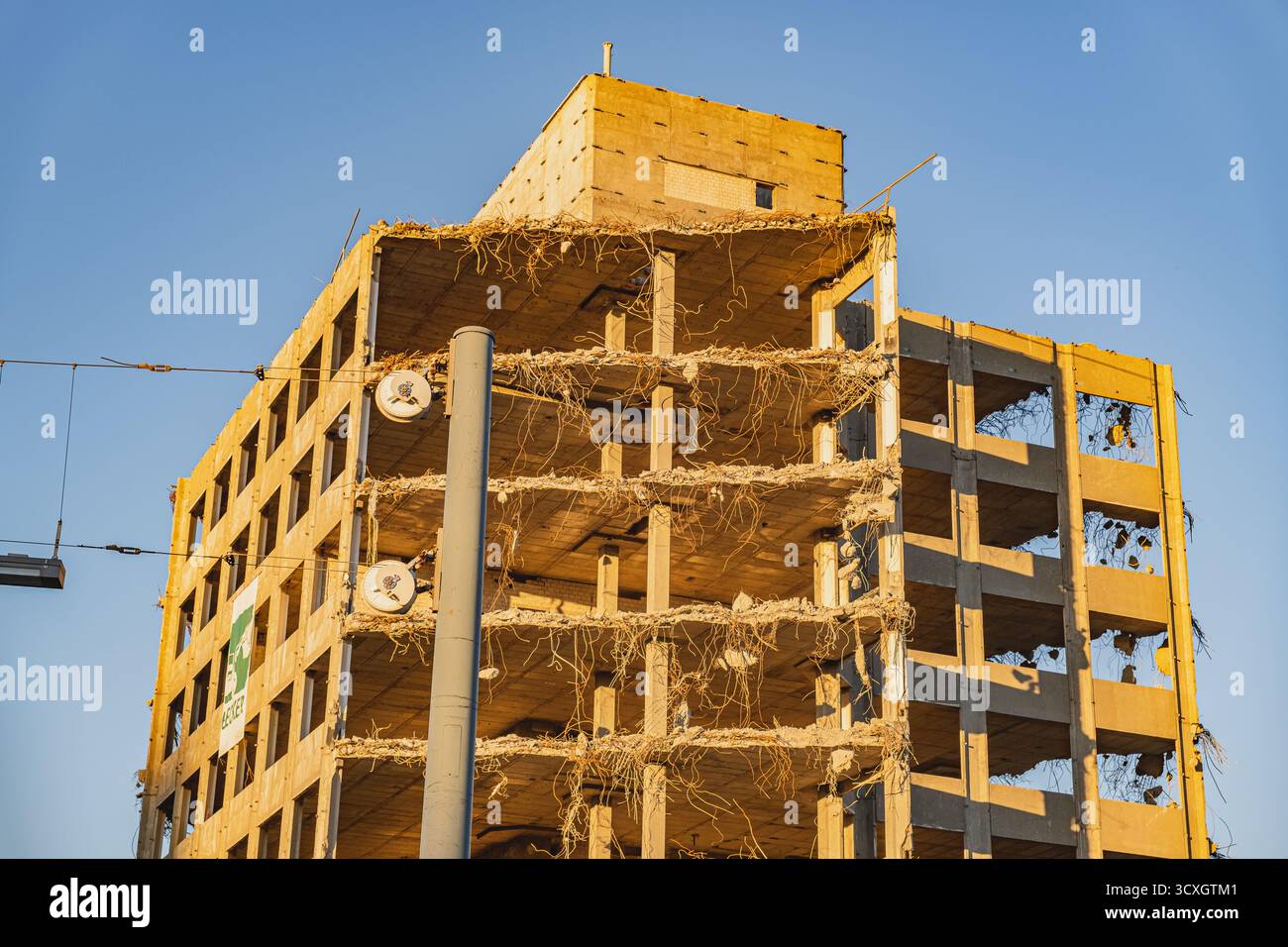 Process of a building demolition, showing a concrete carcass with metal ...
