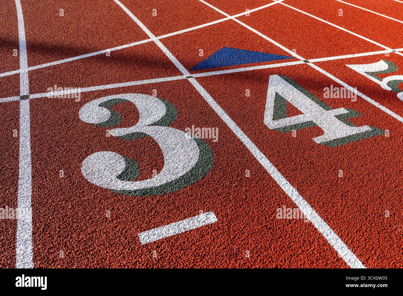 Close up photo of outdoor running track lane white numbers three four ...