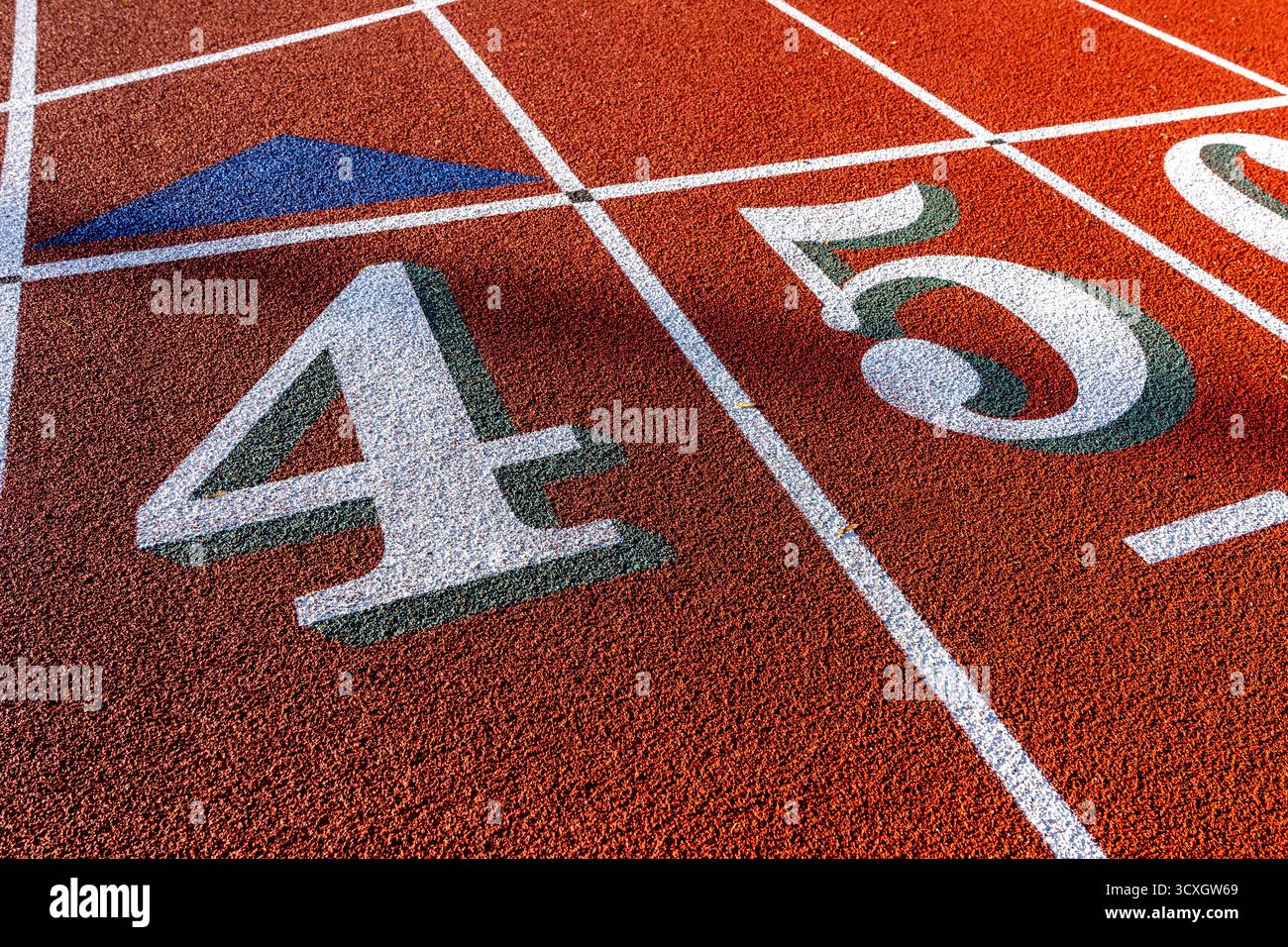 Close up photo of outdoor running track lane white numbers four, five ...