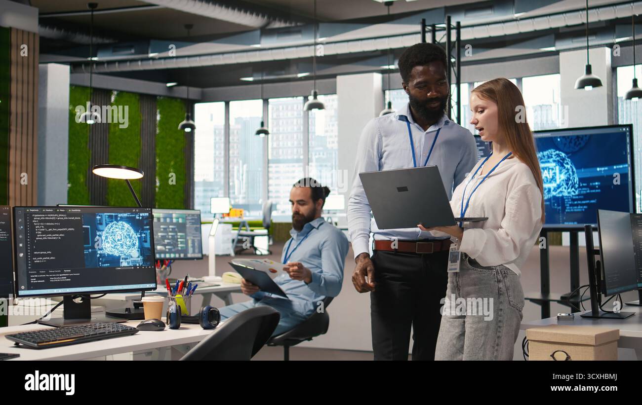 Junior dev and colleague in office reviewing AI system metrics ...