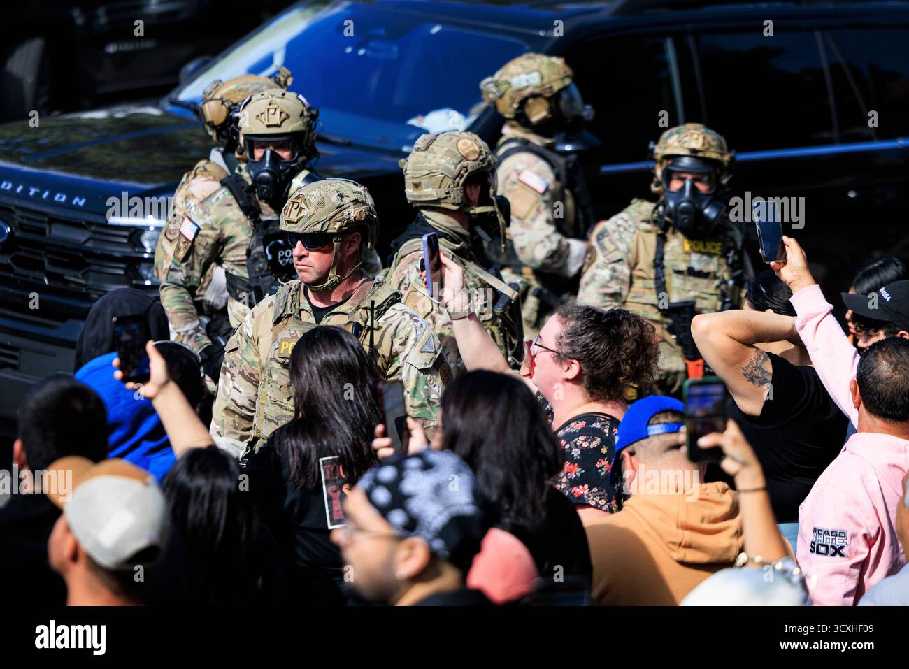 Government officials watch protesters gather in Chicago, Tuesday, Oct ...