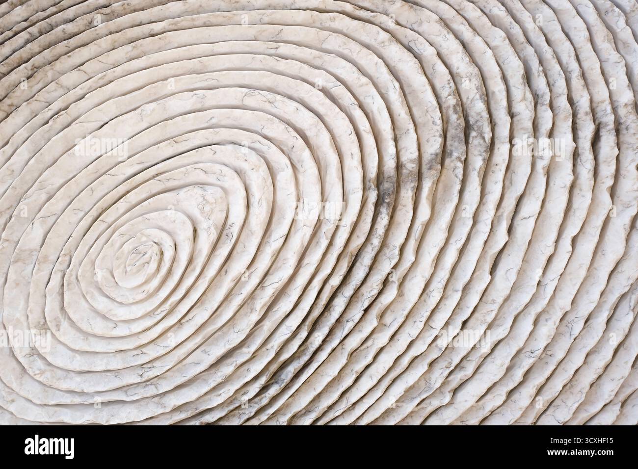 Close-up of concentric circular texture in light stone surface, showing ...
