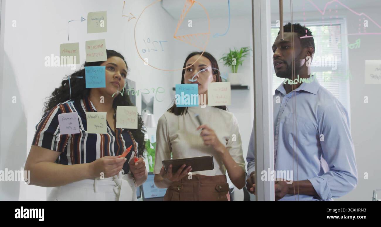 Brainstorming coworkers examining sticky hi-res stock photography and ...