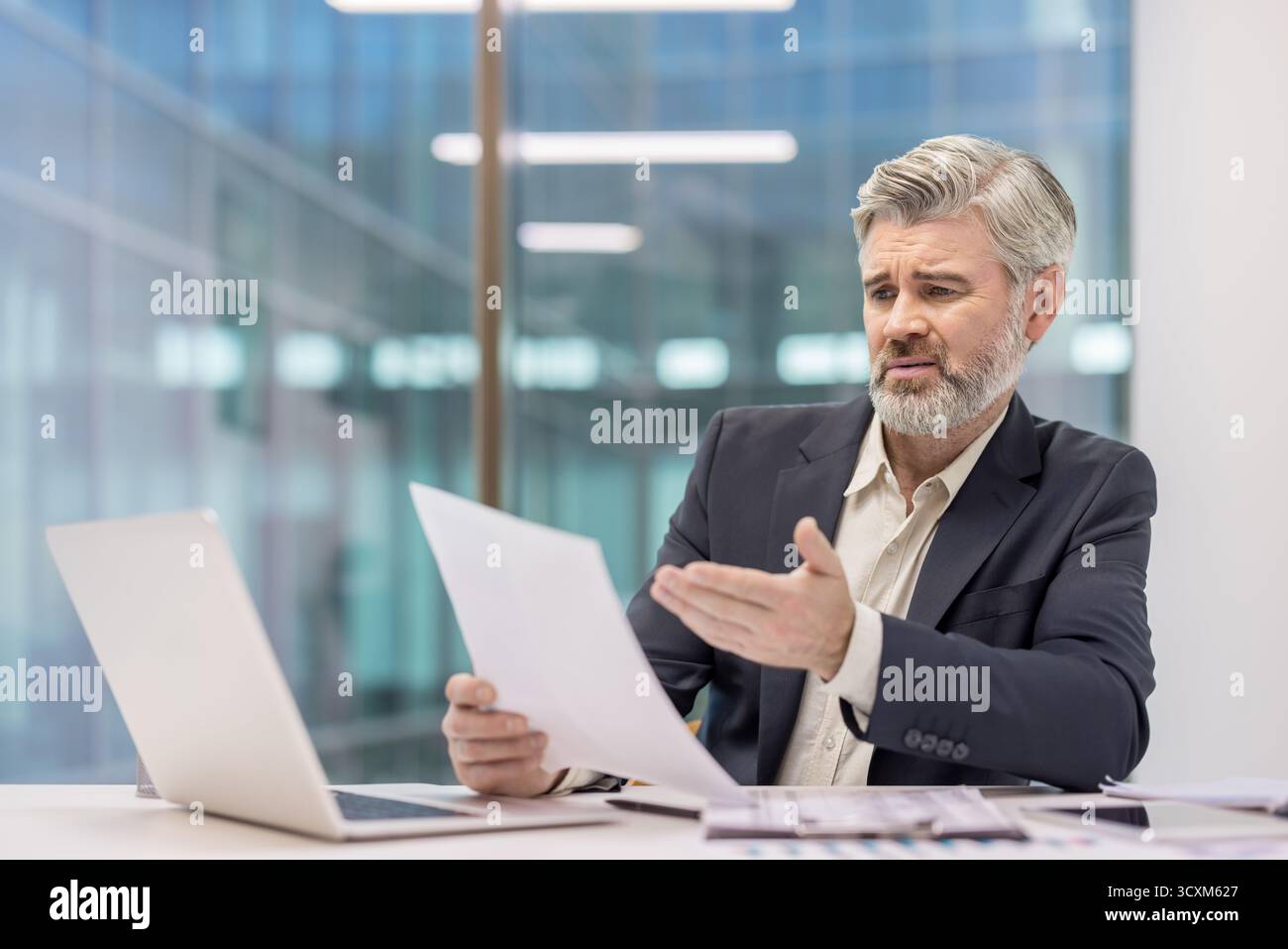 Confused senior businessman with white hair studying financial ...