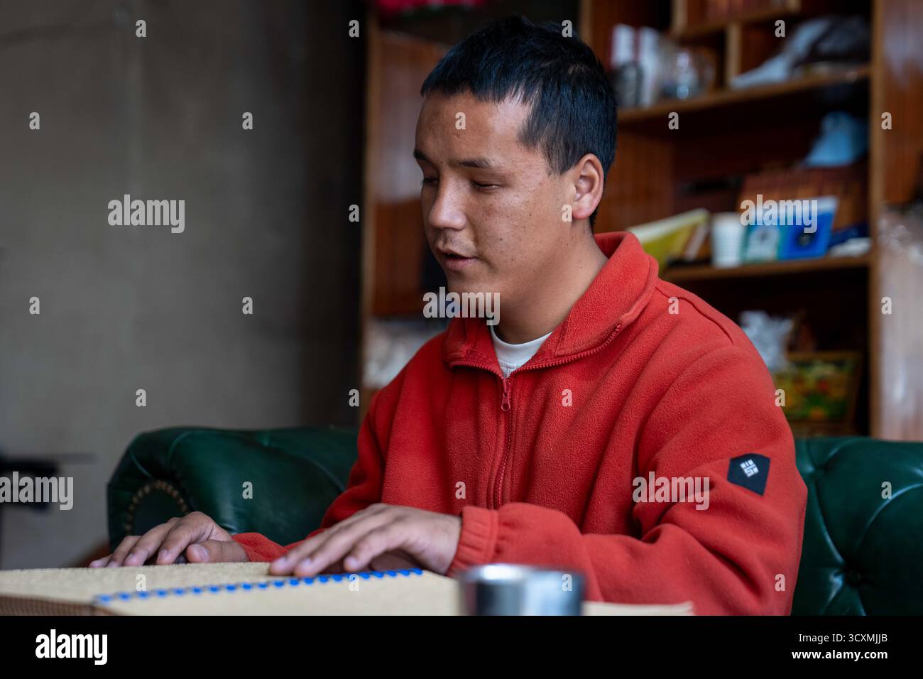 (251015) -- LHASA, Oct. 15, 2025 (Xinhua) -- Tawa Tsering reads a ...