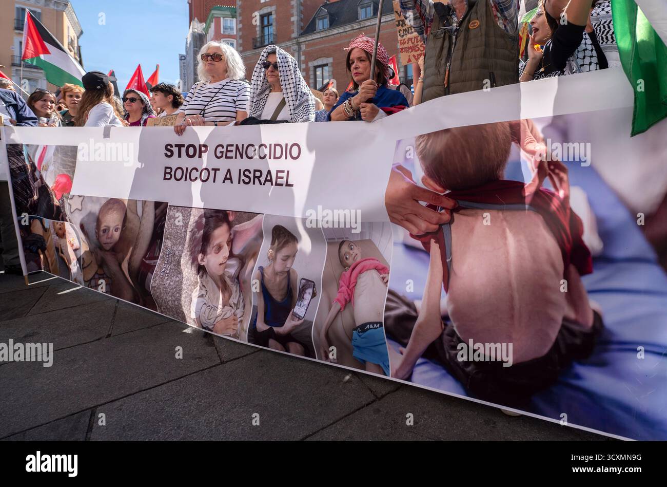 Demonstrators carry a banner with the slogan 'Stop genocide. Boycott ...
