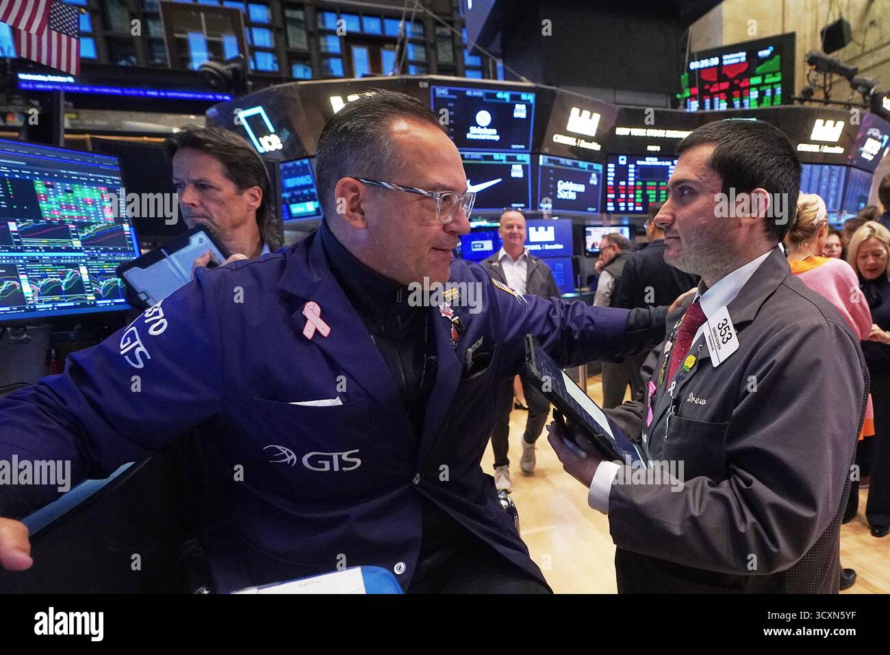 Specialist Anthony Matesic, center, and trader Drew Cohen, right, work ...