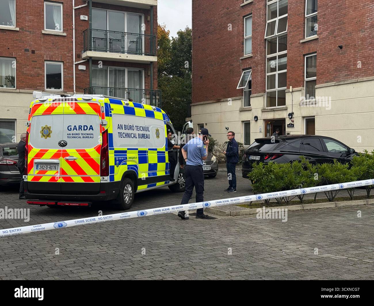 Members of the Garda Technical Bureau behind a crime scene cordon ...