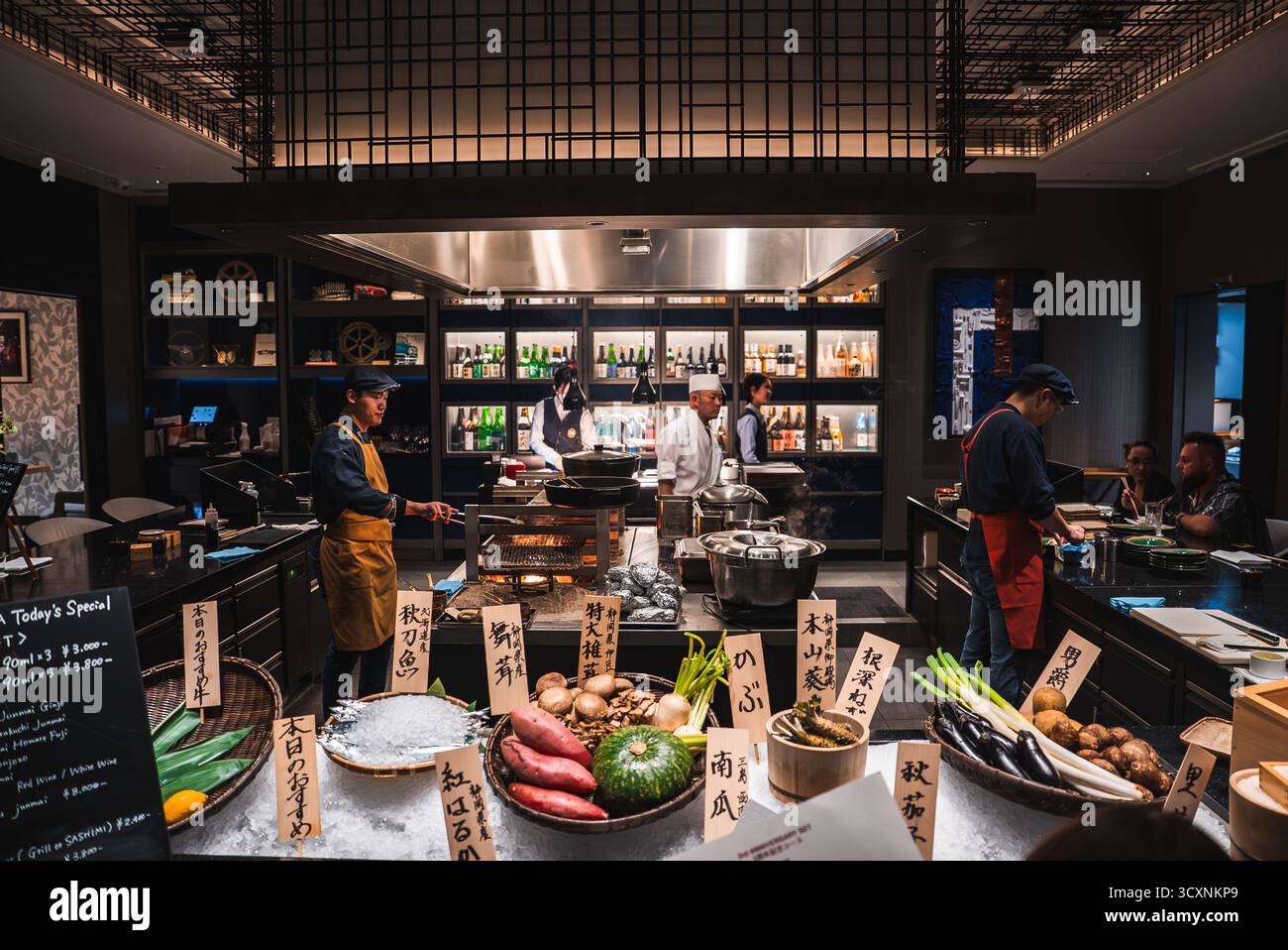 Chefs grill and plate at open kitchen in luxury Japanese restaurant ...