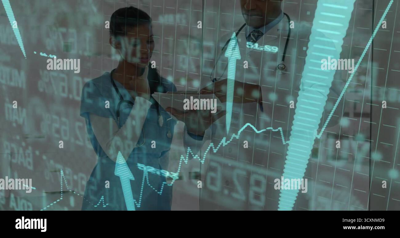 Female and male doctor reviewing tablet data in hospital room, with ...