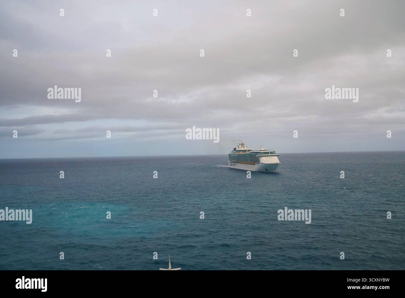 The Liberty of the Seas sails under a cloudy sky, framed by calm ocean ...