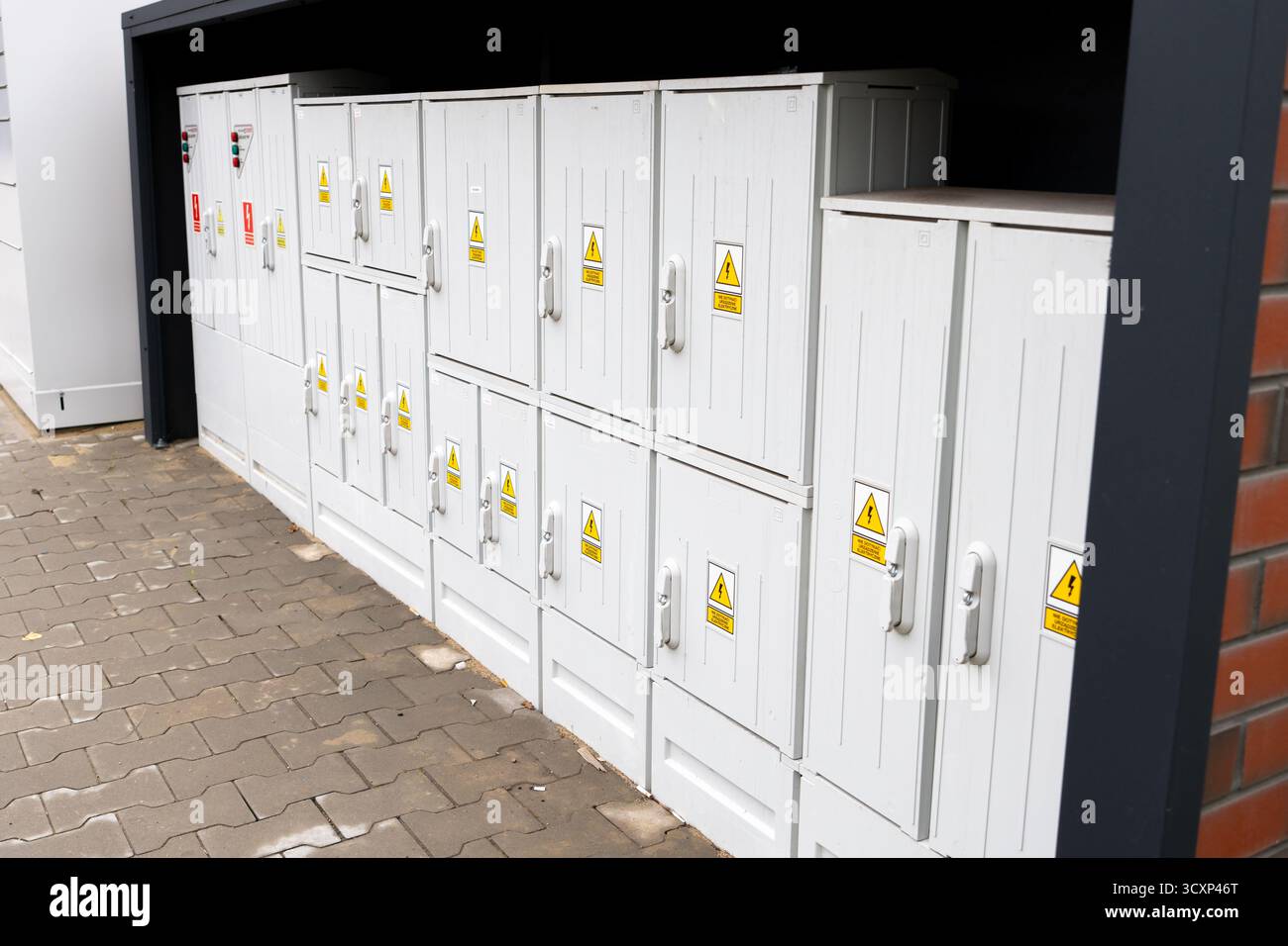 Cluster of small electrical meter boxes mounted on a wall. Utility and ...