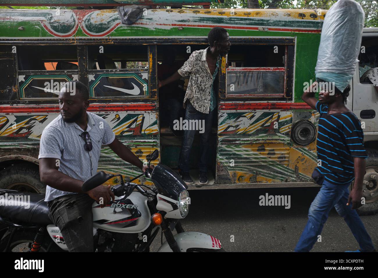 A bus announcer calls out to attract commuters looking for public ...