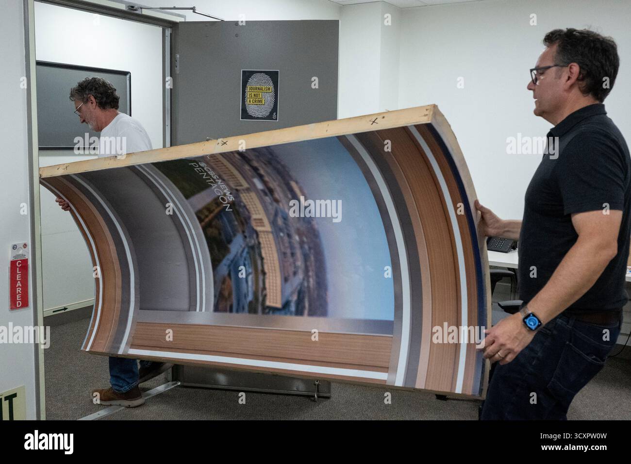 CBS crew members carry out the backdrop from their broadcast booth in ...