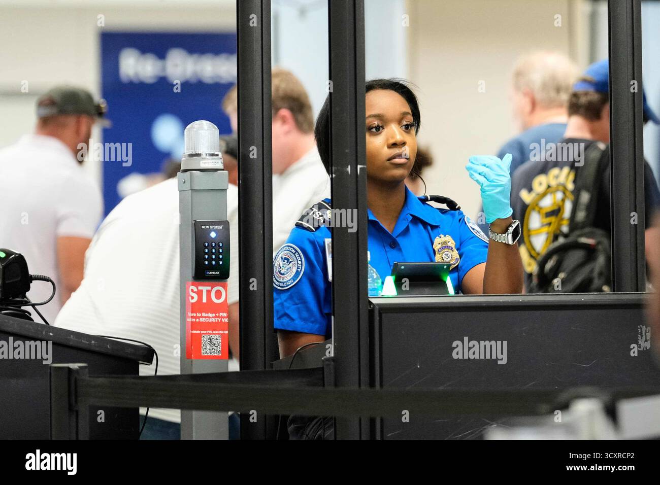 A TSA agent interacts with travelers at a security checkpoint at Dallas ...