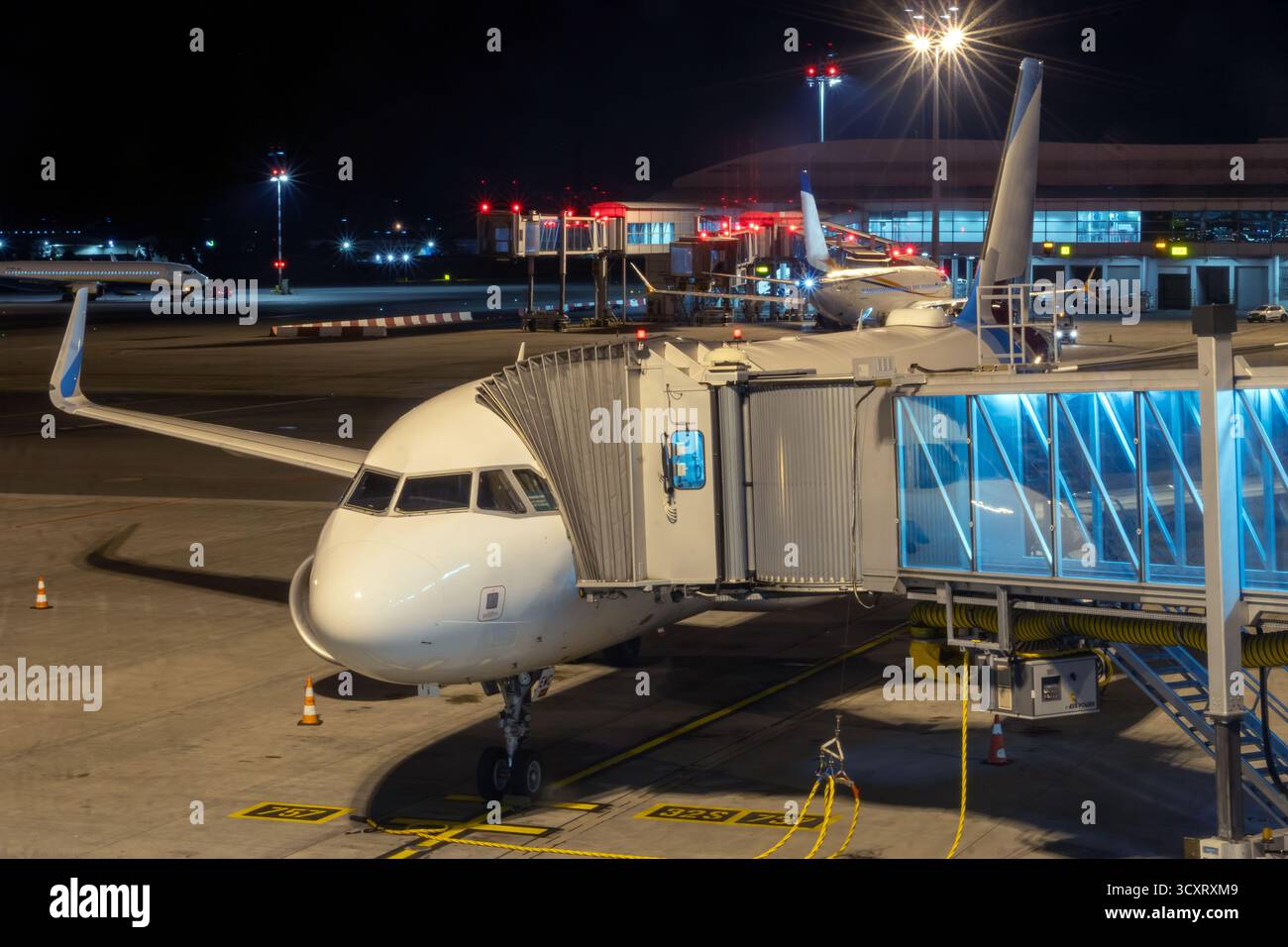 The plane stands at the boarding bridge at night Stock Photo - Alamy