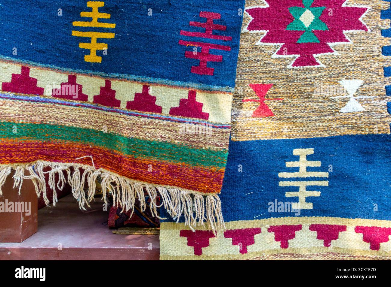 Traditional colorful woven rugs with geometric patterns stacked on a ...