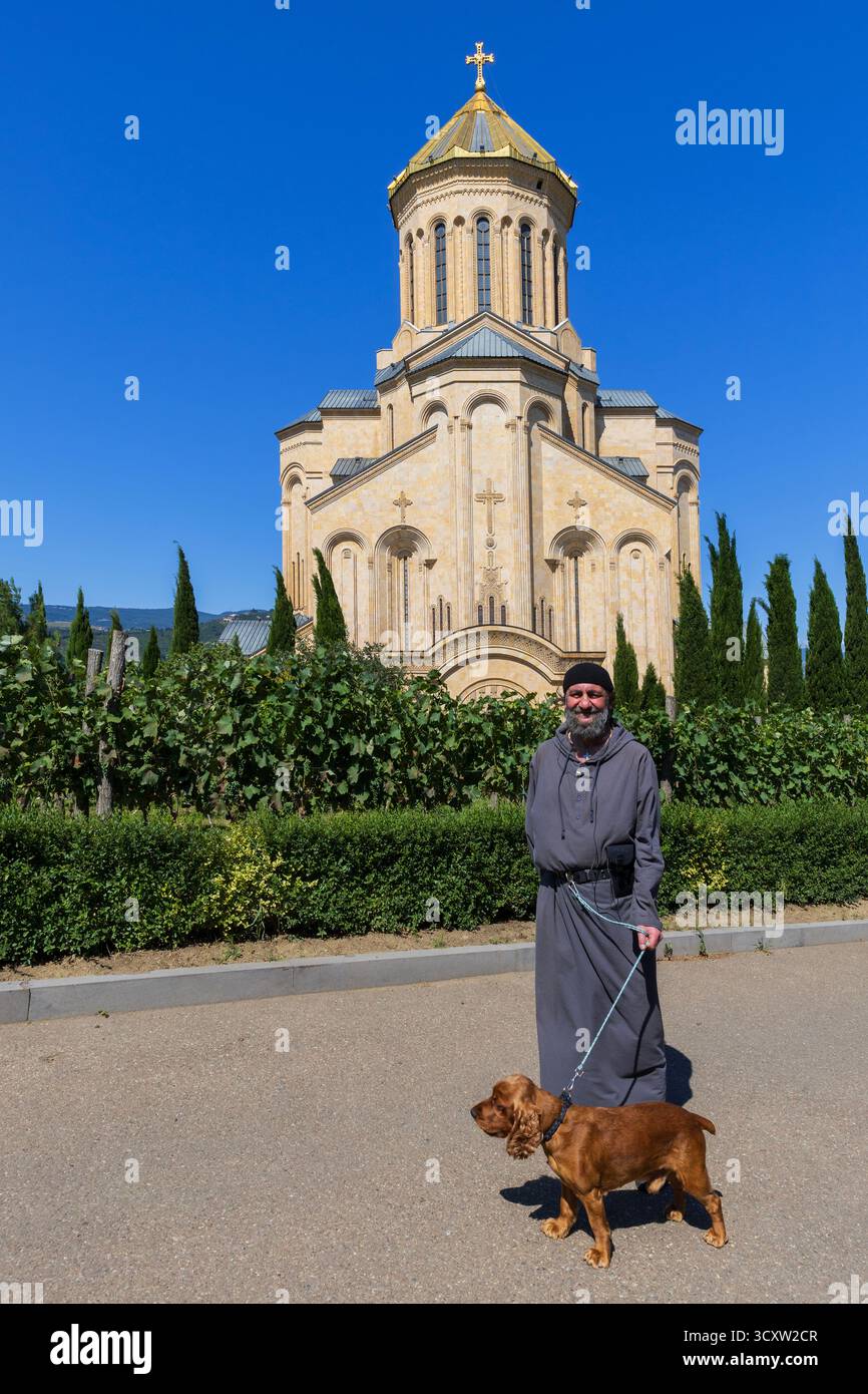 An Eastern Orthodox priest walking his dog among the vineyards of the ...