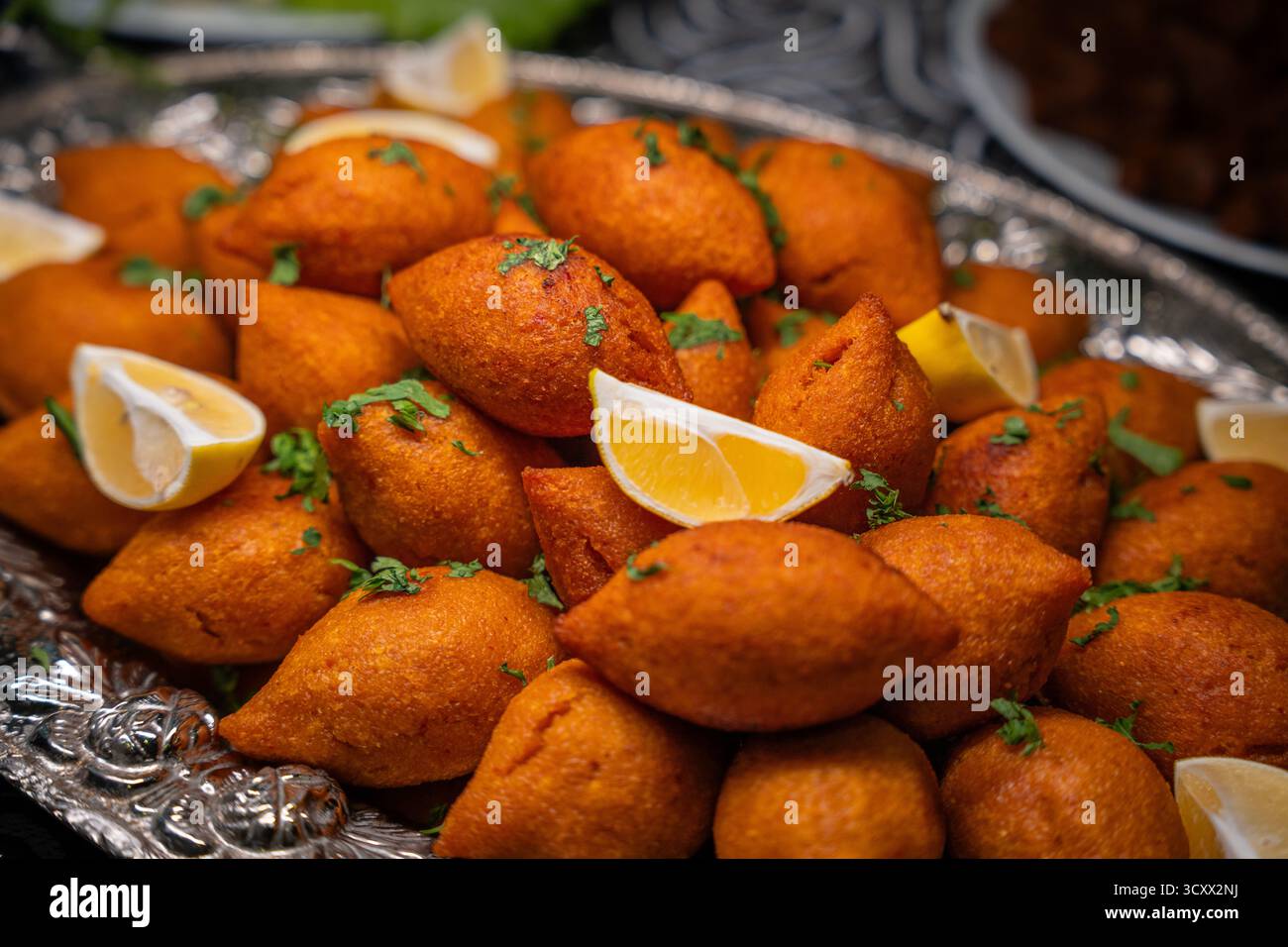 Traditional Turkish and Arap icli kofte served with lemon wedges on ...