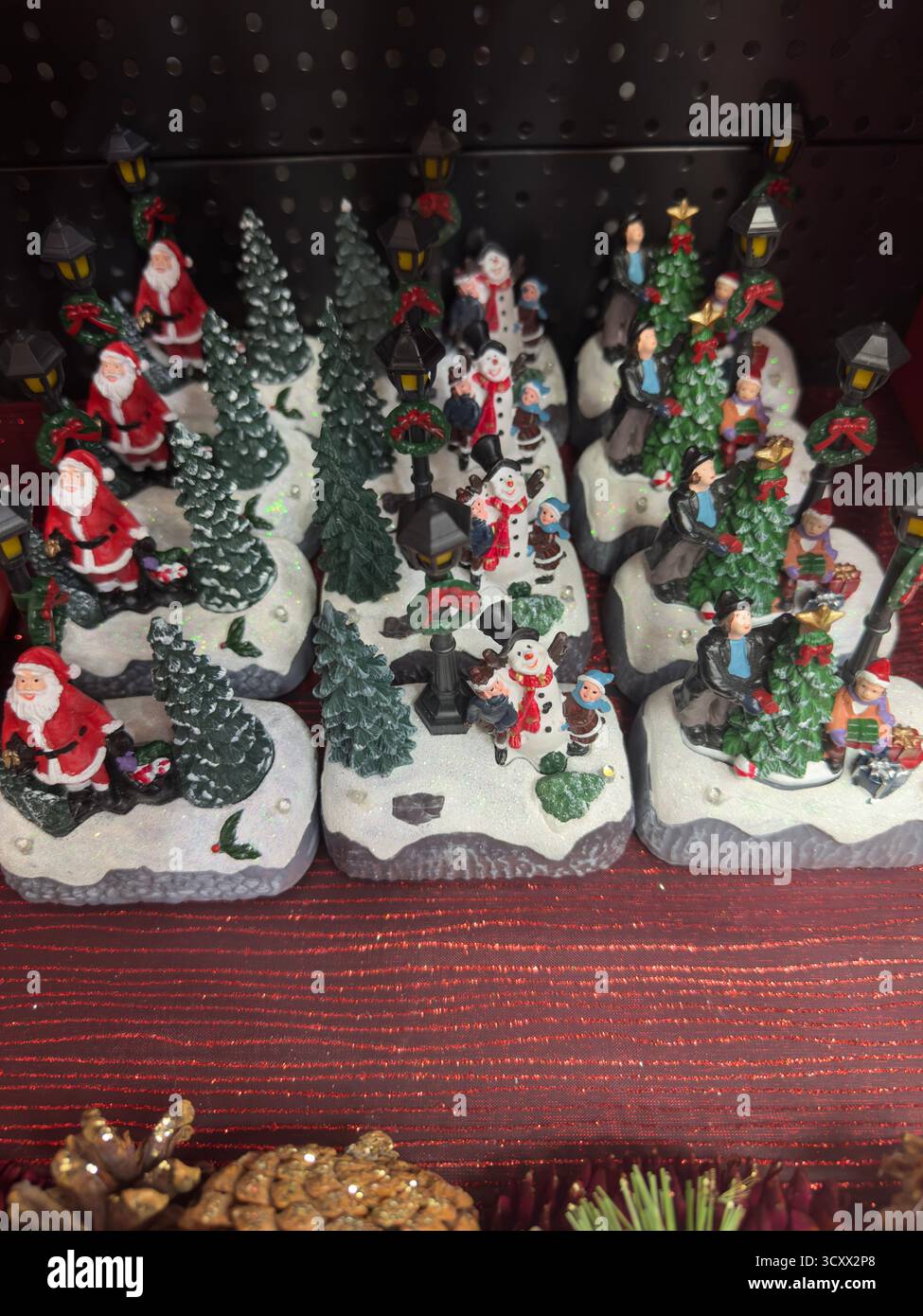 A festive display of miniature Christmas village scenes featuring Santa ...