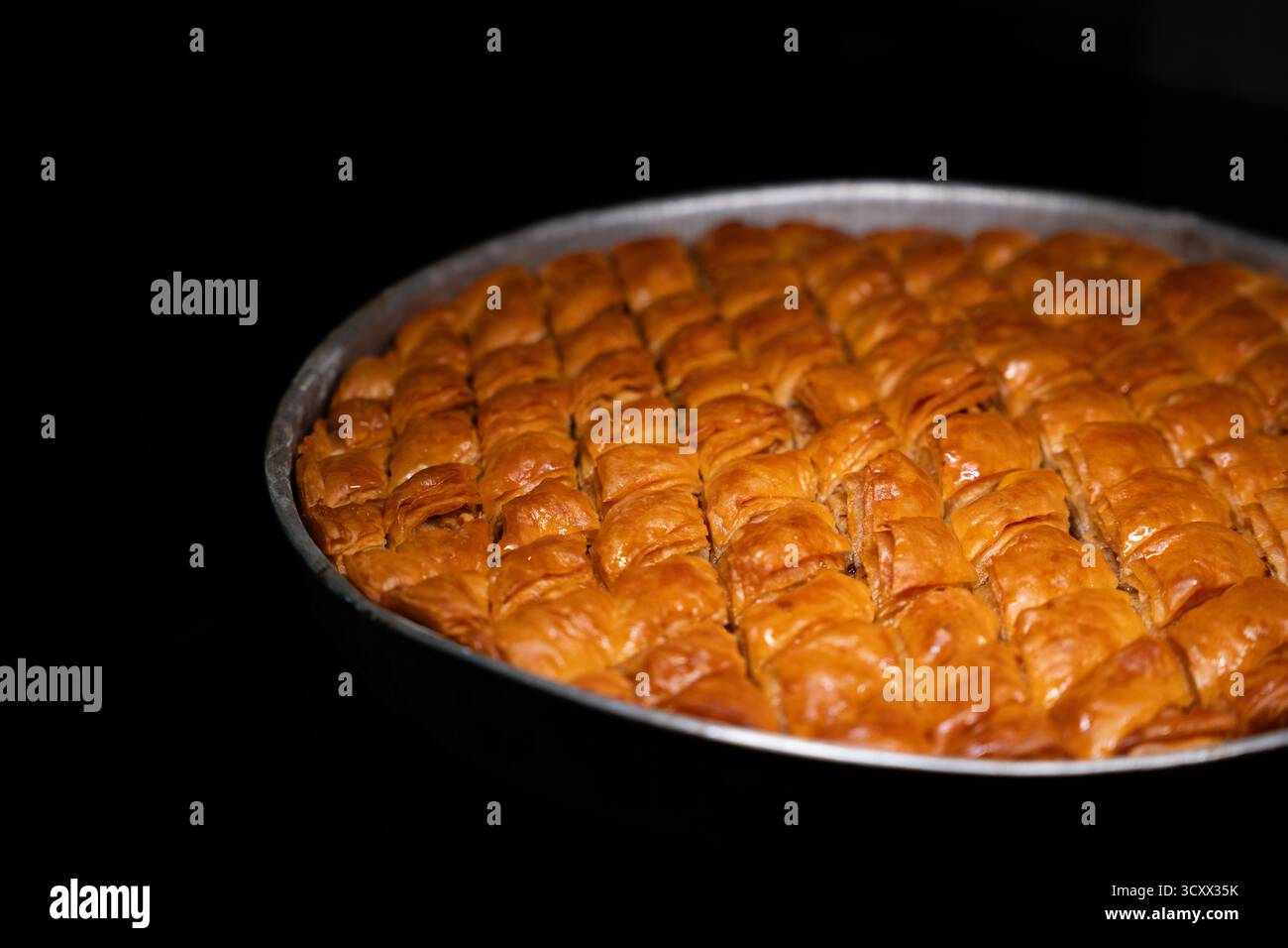 Large, round metal tray filled with freshly baked, glossy, diamond-cut ...