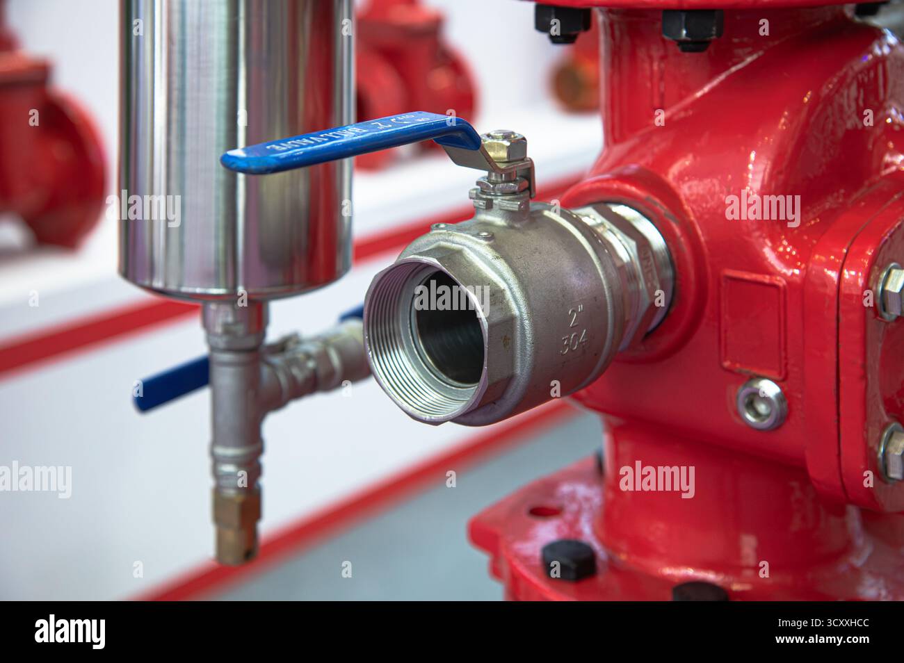 A red fire hydrant with a blue ball valve. The valve is connected to a ...