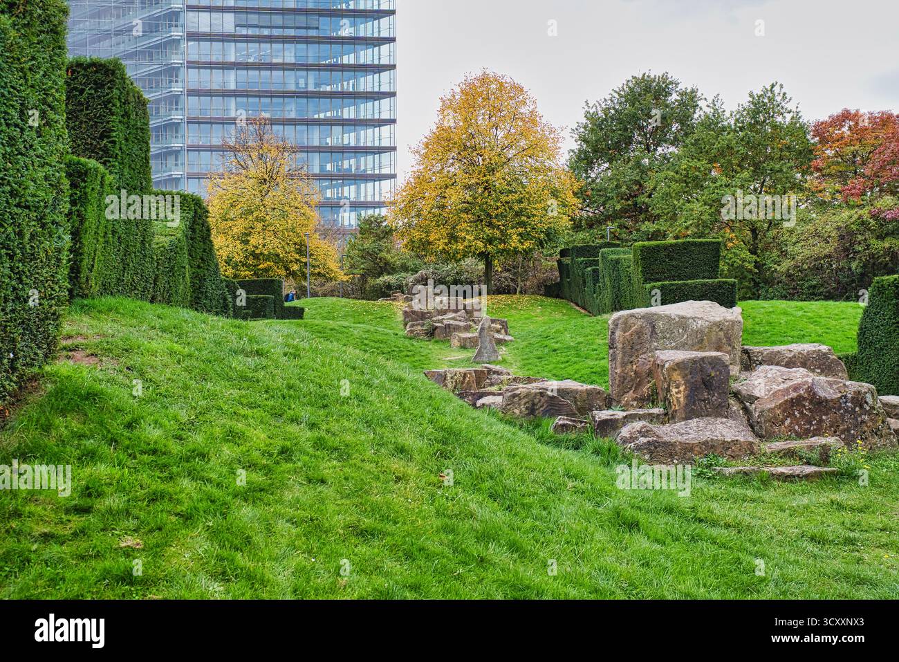 Modern Glass High-Rise Skyscraper Overlooking Sculpted Green Hedges and ...