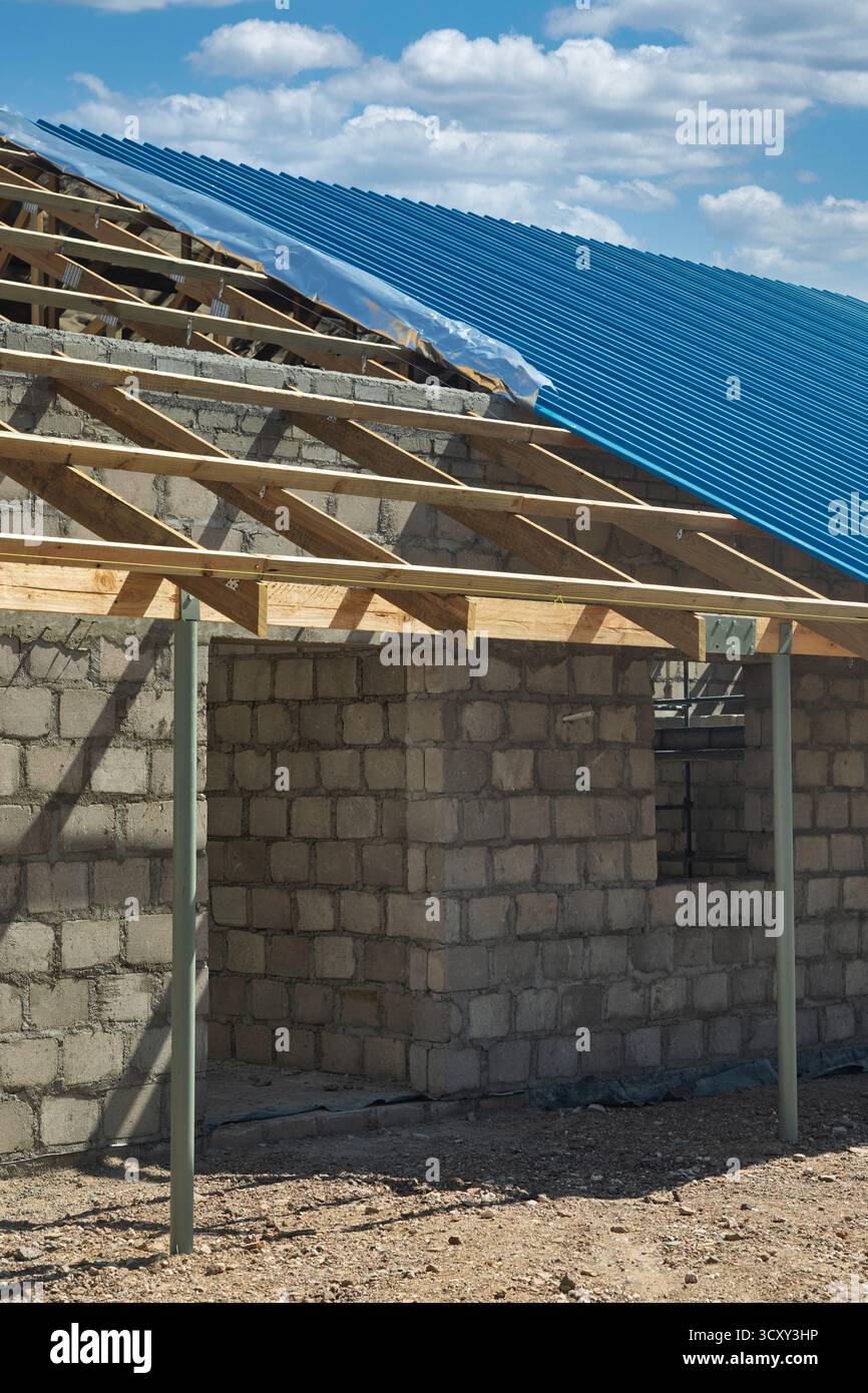 building with unfinished roof, half done, corrugated sheet and trusses ...