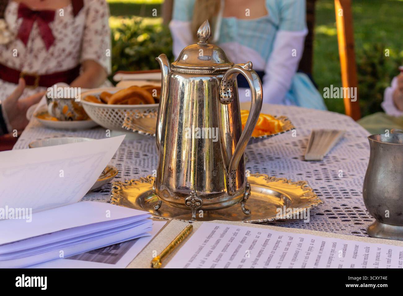 A beautiful silver teapot on a table during an outdoor historical ...