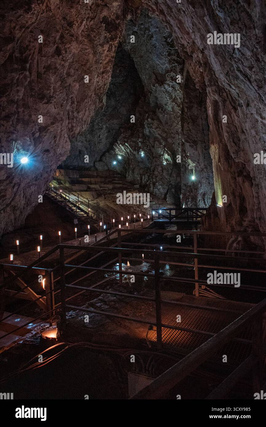 The interior of a cave with a pathway illuminated by small lights Stock ...