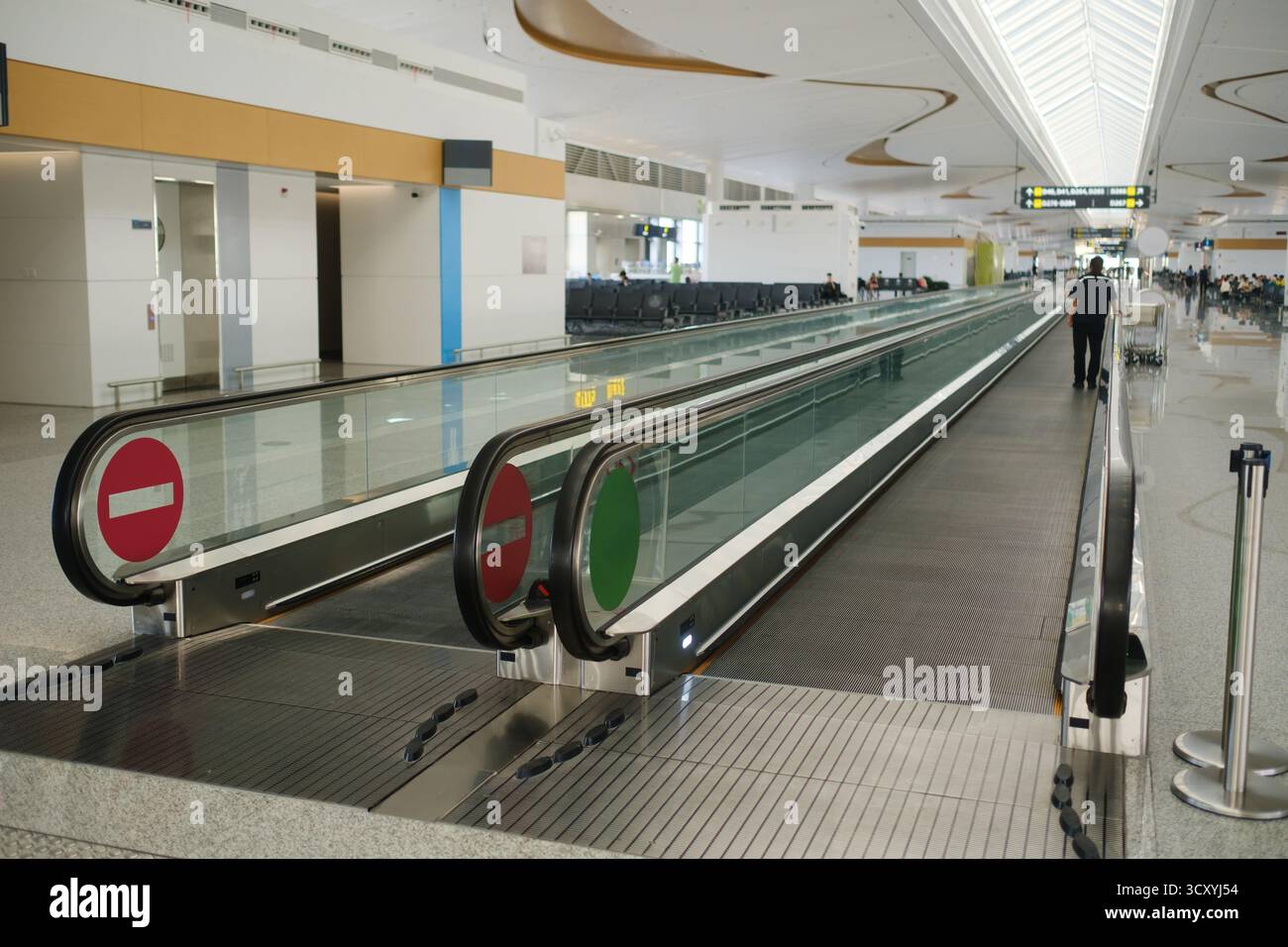 Travelers use a moving walkway designed for convenience at a spacious ...