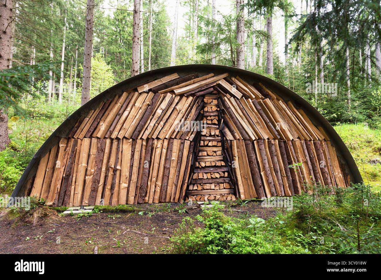 Creative woodpile structure shaped like a half dome stands in a ...