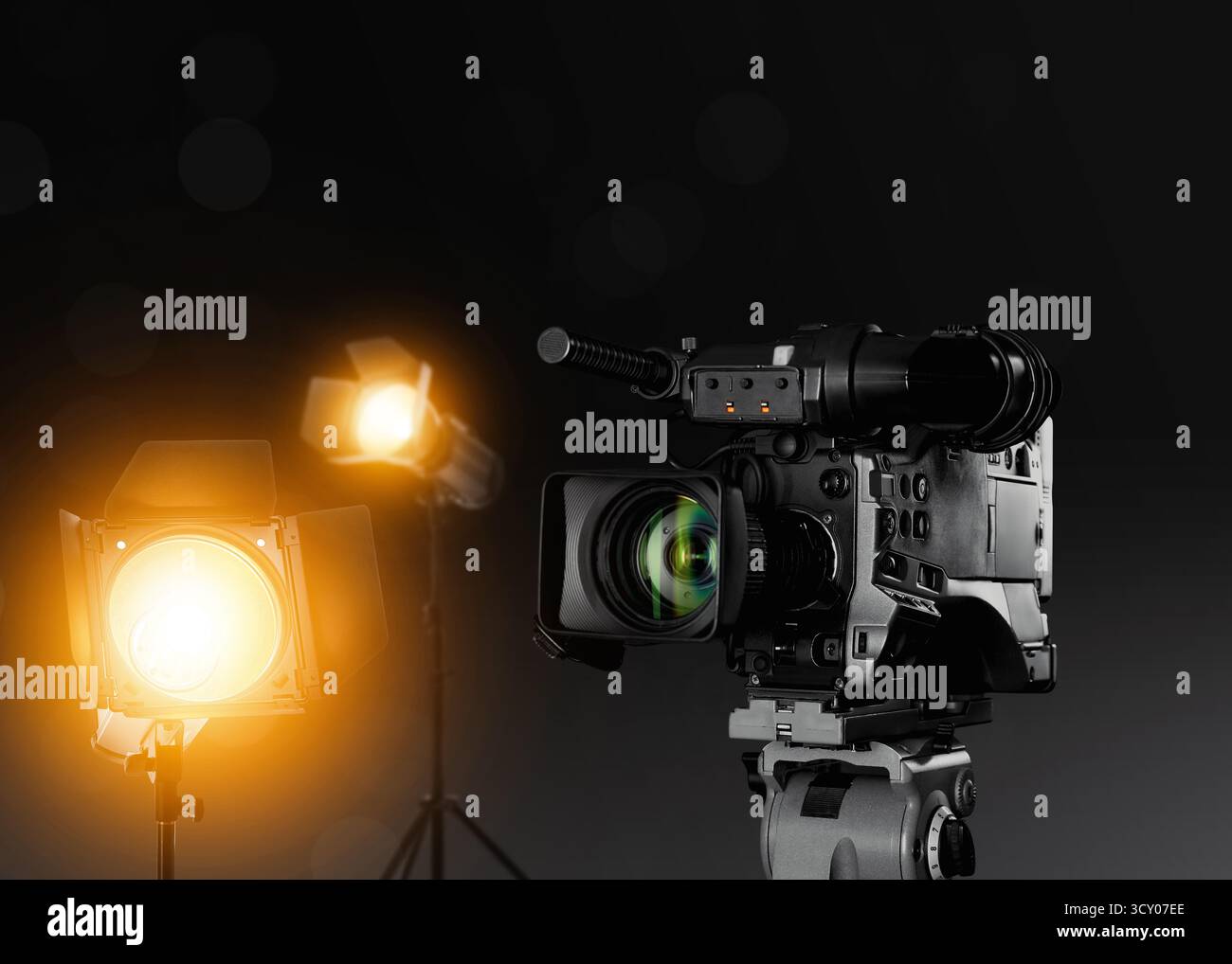 Cinema production. Professional camera and spotlights against dark ...