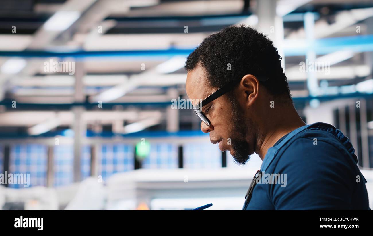 Portrait of engineer in photovoltaics factory reviewing paperwork to ...