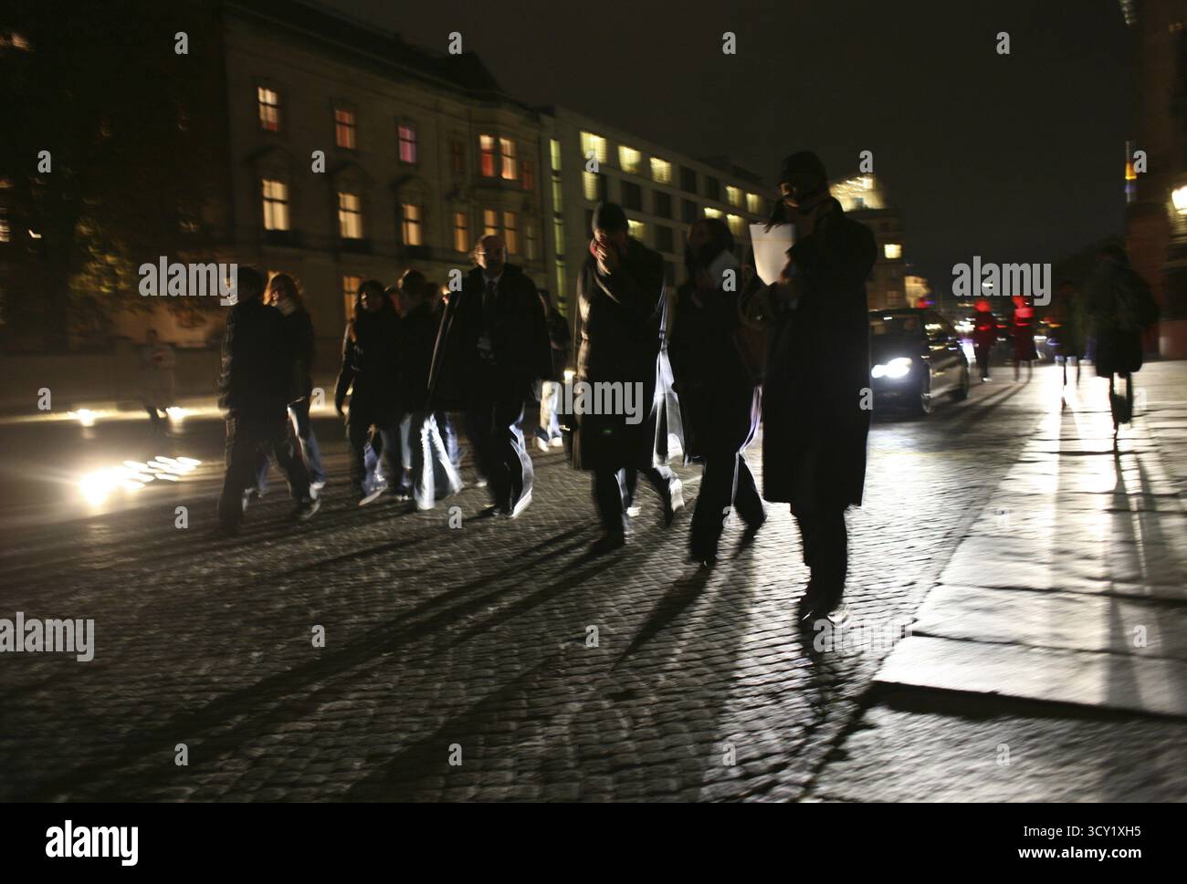 Visitors cast their shadows on the pavement as they leave the Reichstag ...