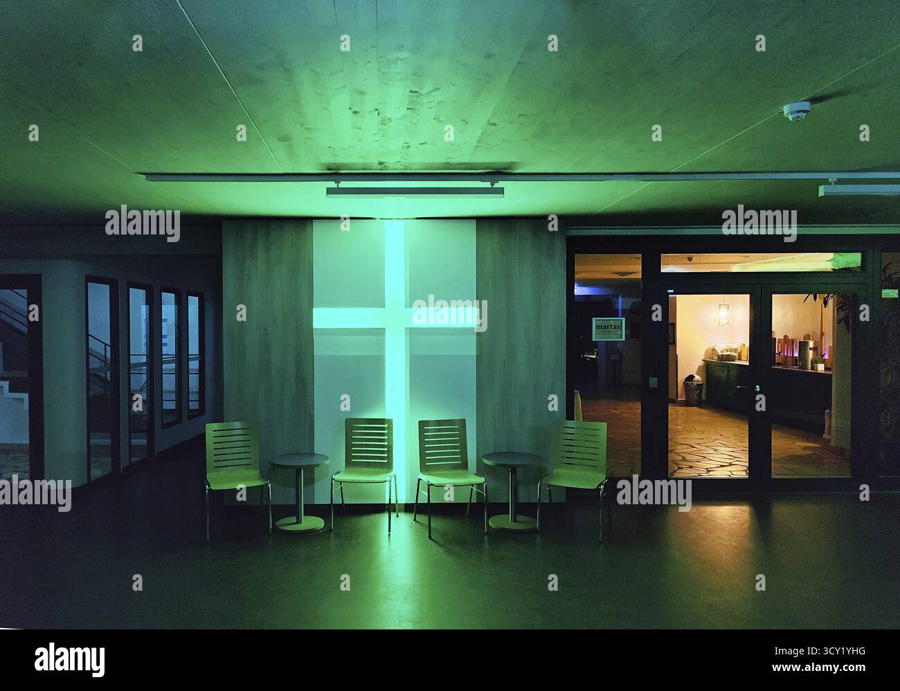 Green illuminated entrance area of the Berlin City Mission at night ...