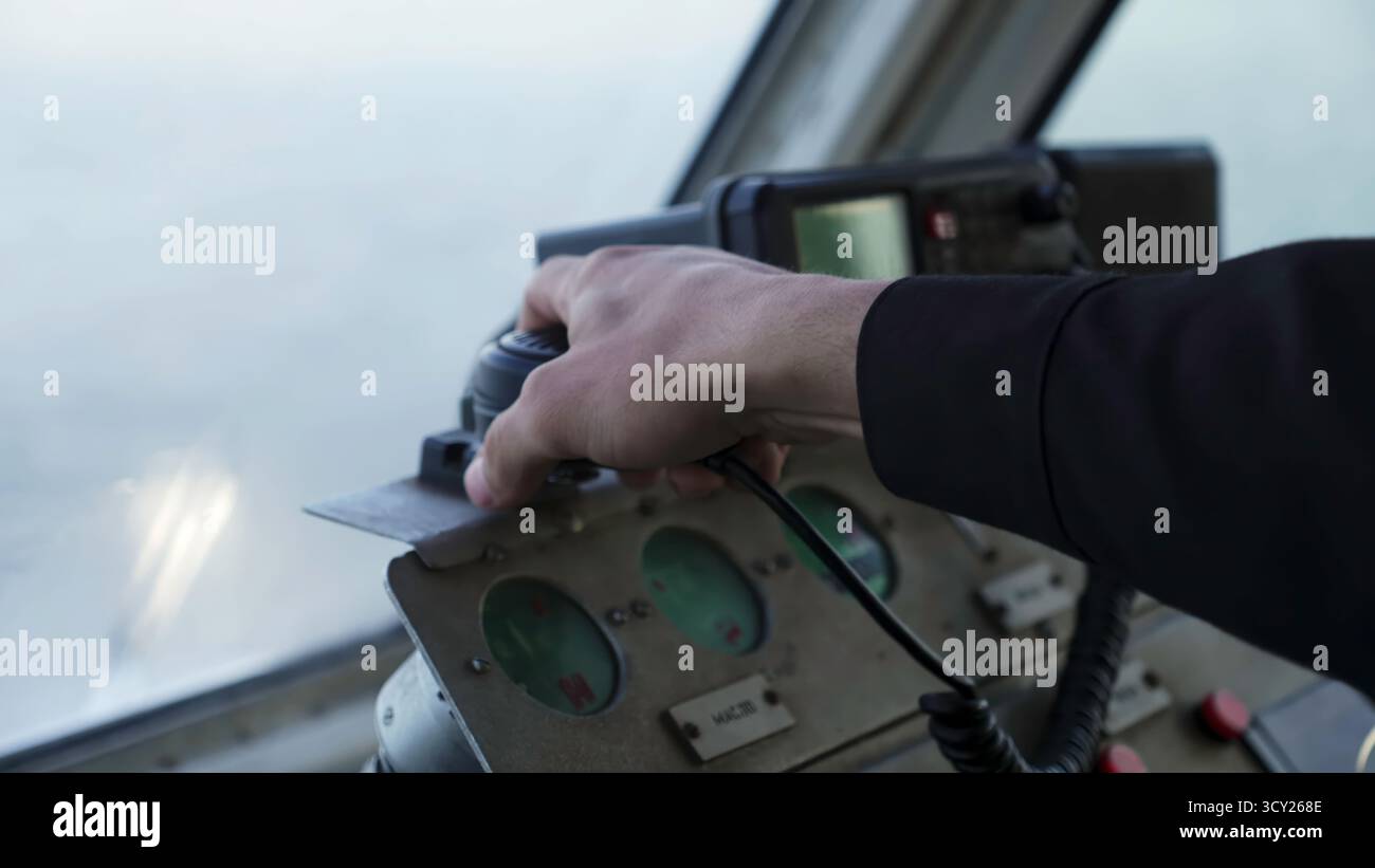 Captain using vhf radio and adjusting controls on ship's bridge. Clip ...