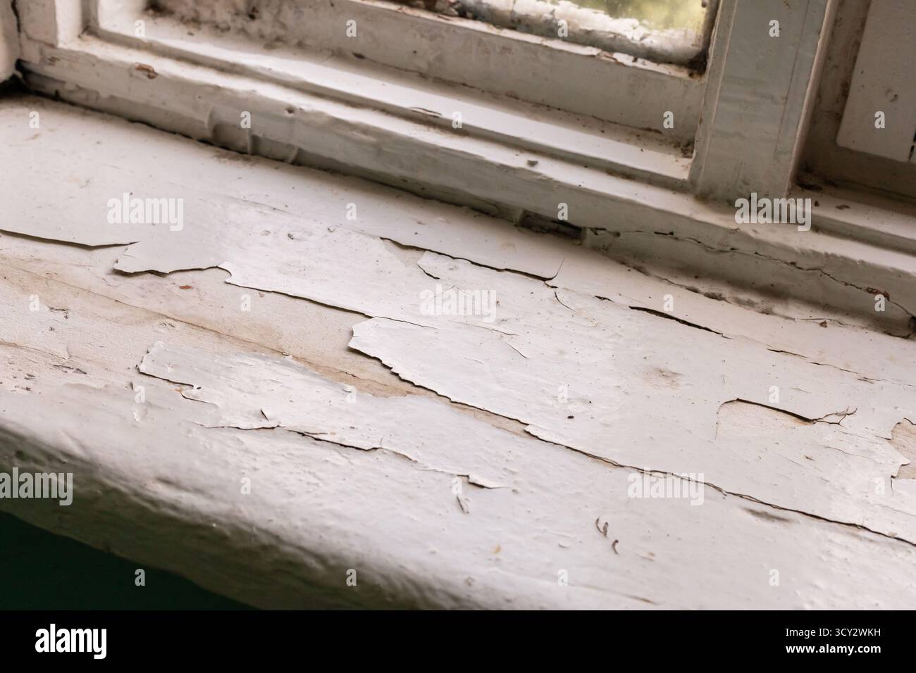 Window sill of an old house reveals significant damage with peeling ...