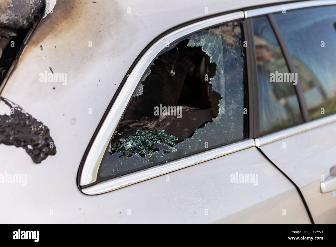 A burned vehicle shows severe damage with a shattered rear window where ...