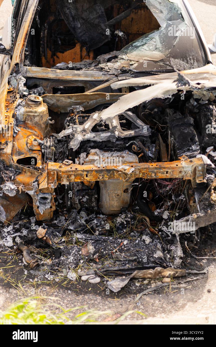 A car that caught fire is now a burnt shell, showing severe damage ...