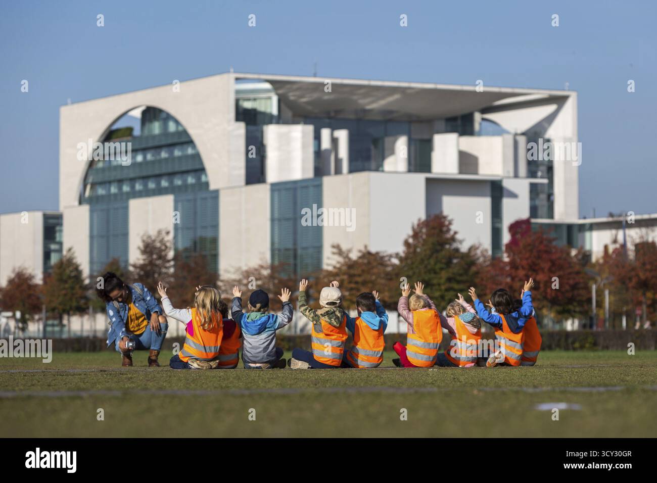 DEU Germany Germany Berlin Kindergarten children raise their hands for ...