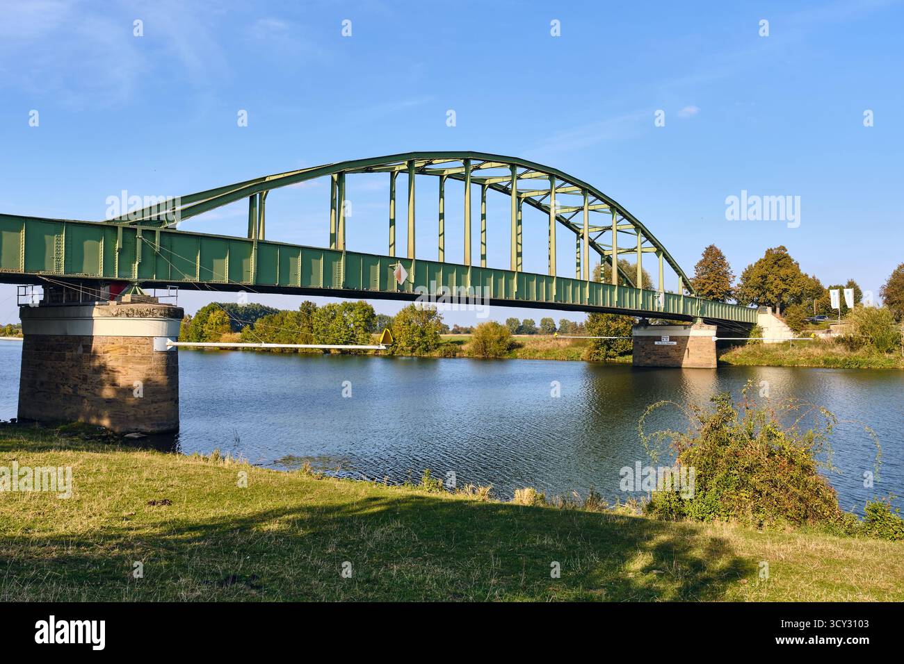 Verden, Germany ; October 2, 2025: Green steel arch bridge spanning the ...