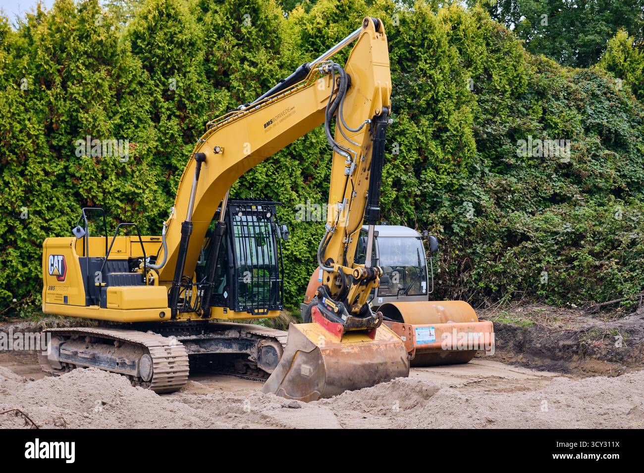 Bassum, Germany; oct 3, 2025: yellow Caterpillar excavator and orange ...