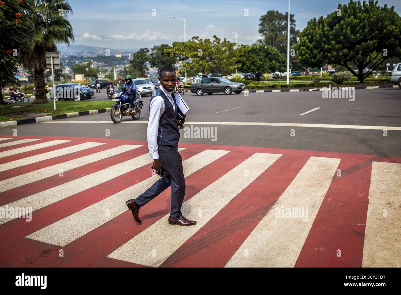RWA RWANDA RUANDA Kigali A pedestrian in a suit crosses a zebra ...