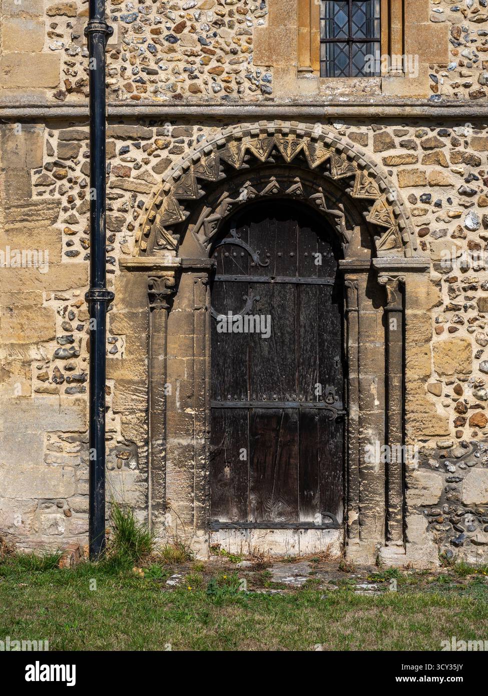 Wooden side door with elaborate carved stone surround on the 12th ...