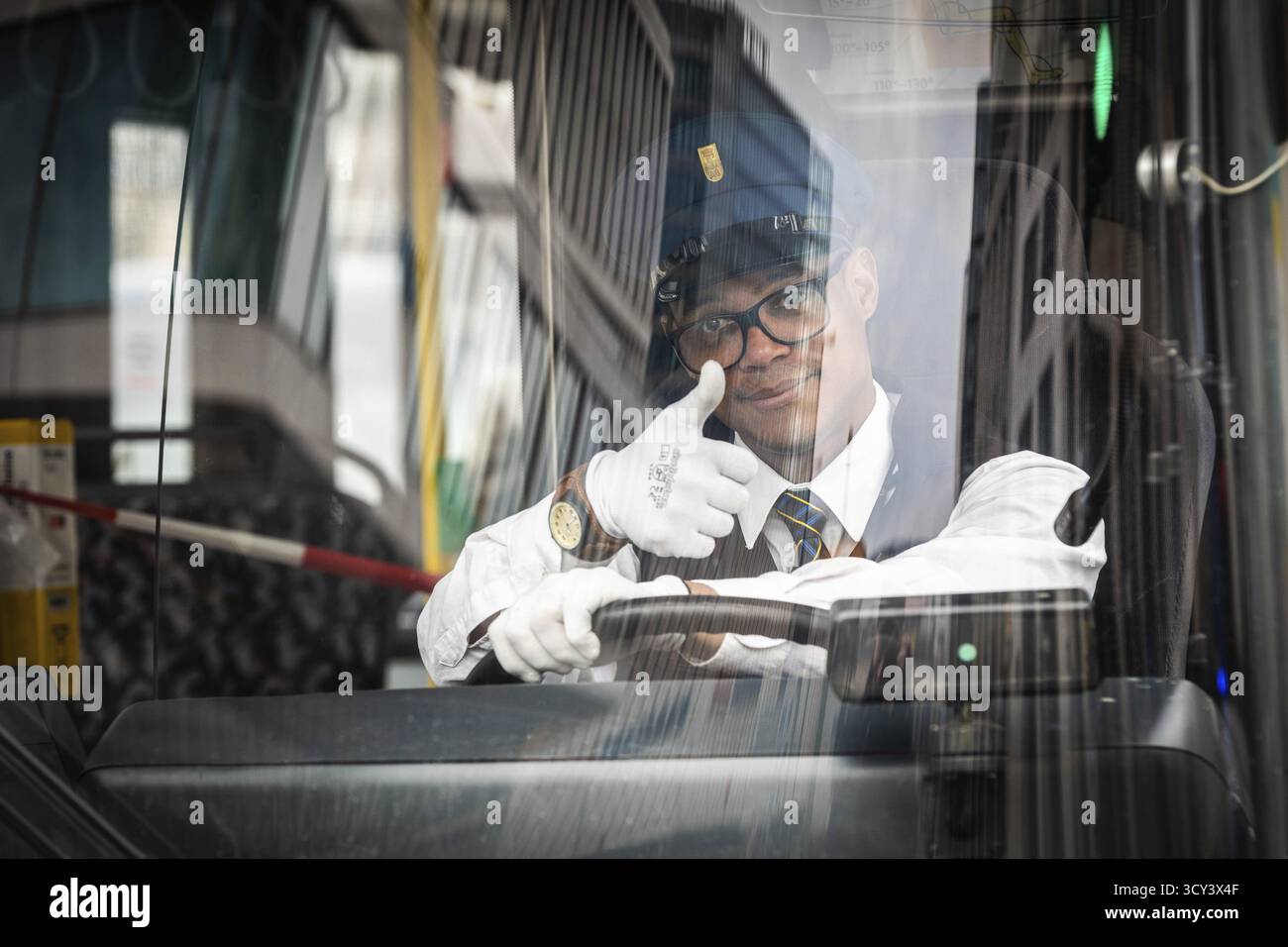 DEU Germany Germany Berlin BVG bus driver, with white gloves, gives the ...