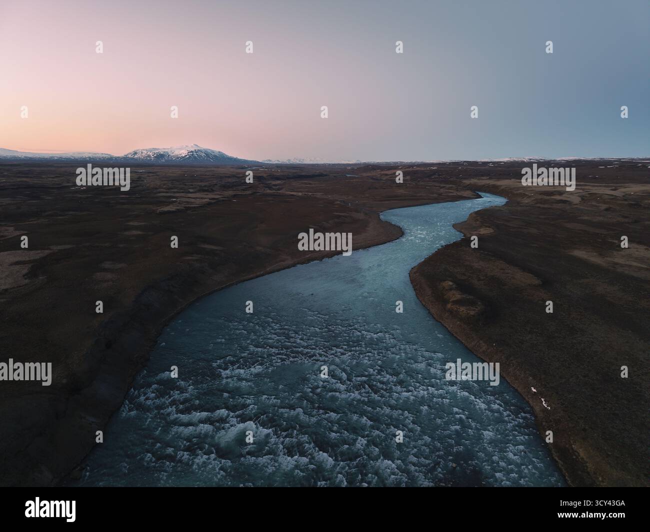 Aerial view of a glacial river winding through a stark landscape under ...