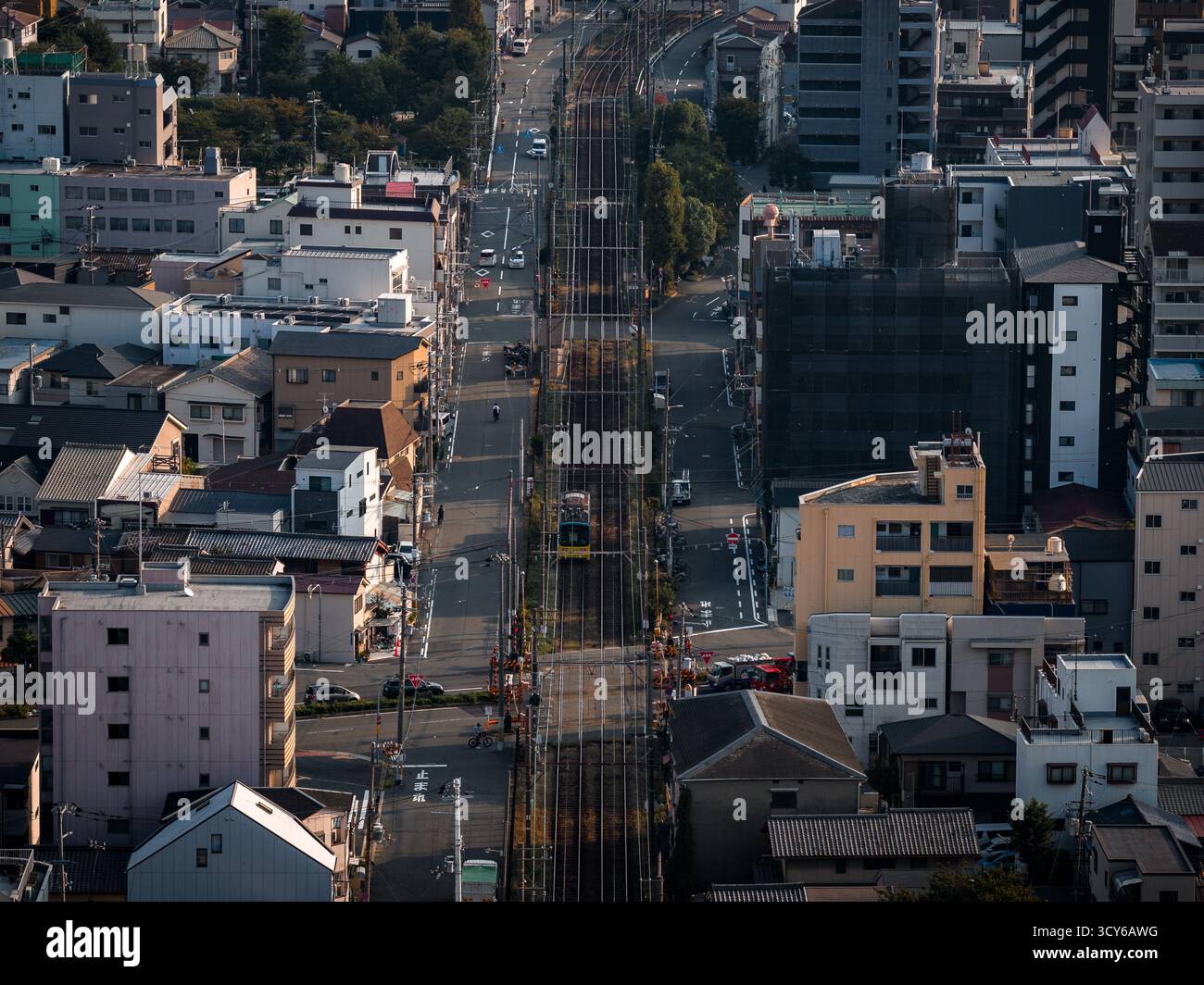 Aerial high angle tram corridor through Osaka with rails and wires ...