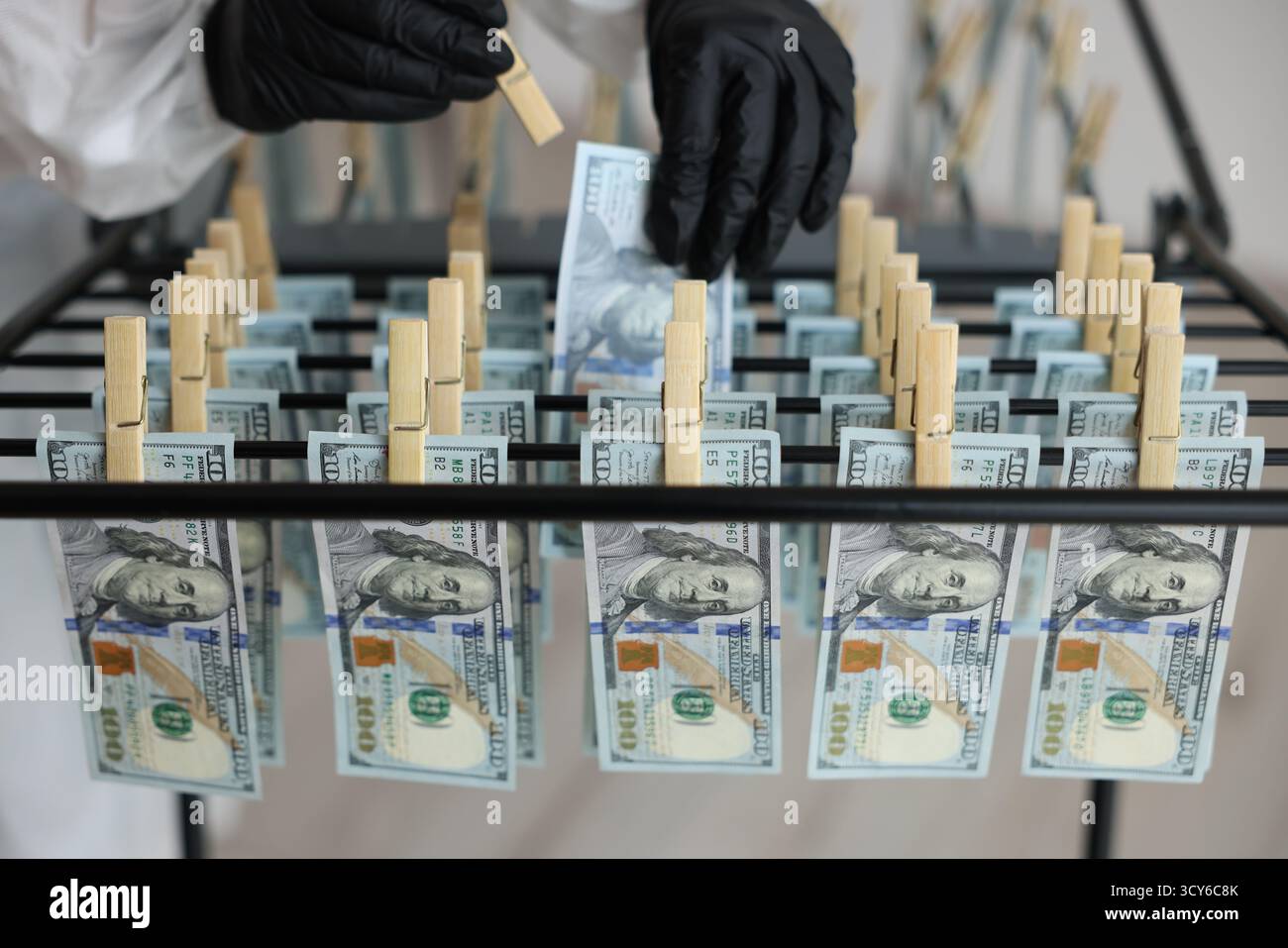 Money laundering. Woman hanging banknotes on drying rack indoors ...